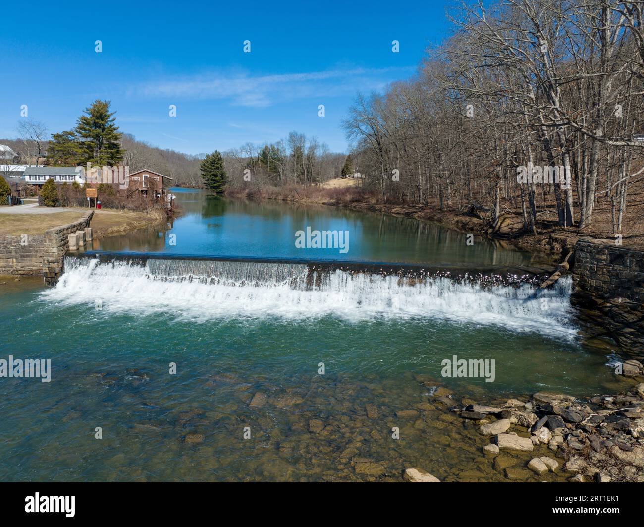 A body of water cascades from a hydroelectric dam, creating a powerful ...