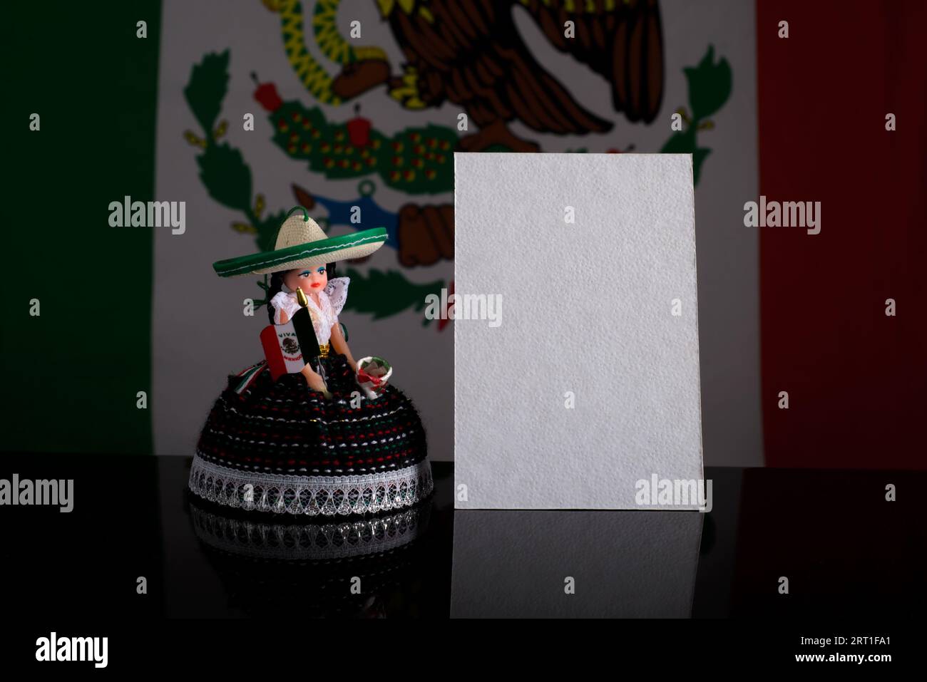 Small doll with Mexican woman figure next to a blank card with Mexican ...