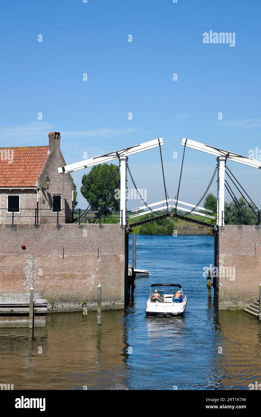 Harbor of Heusden with quay wall, white drawbridge, boats and mill ...