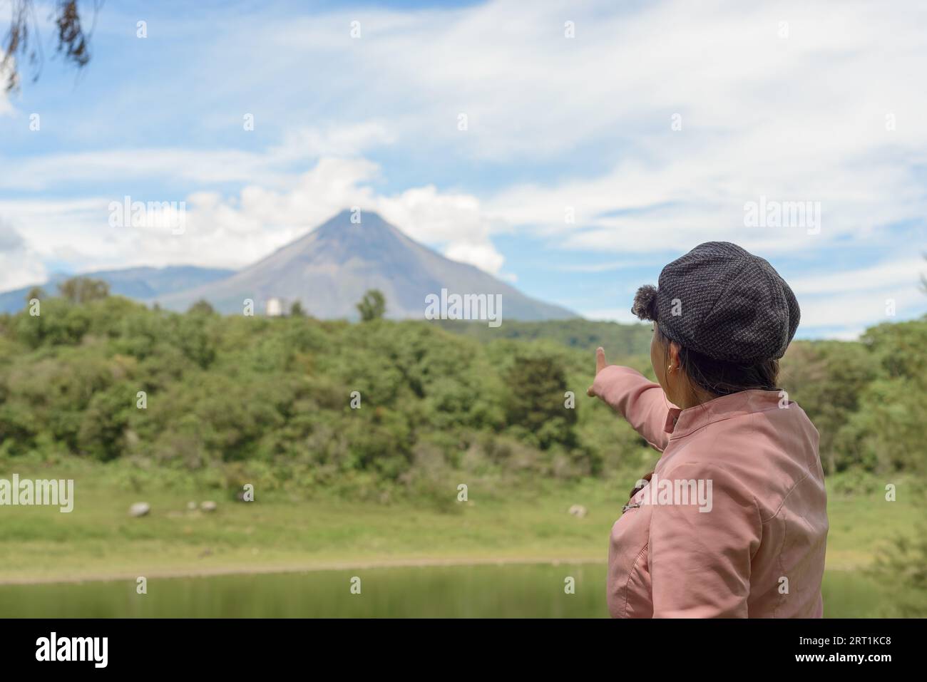 Woman pointing to the Colima volcano from the Carrizalillos Lagoon ...