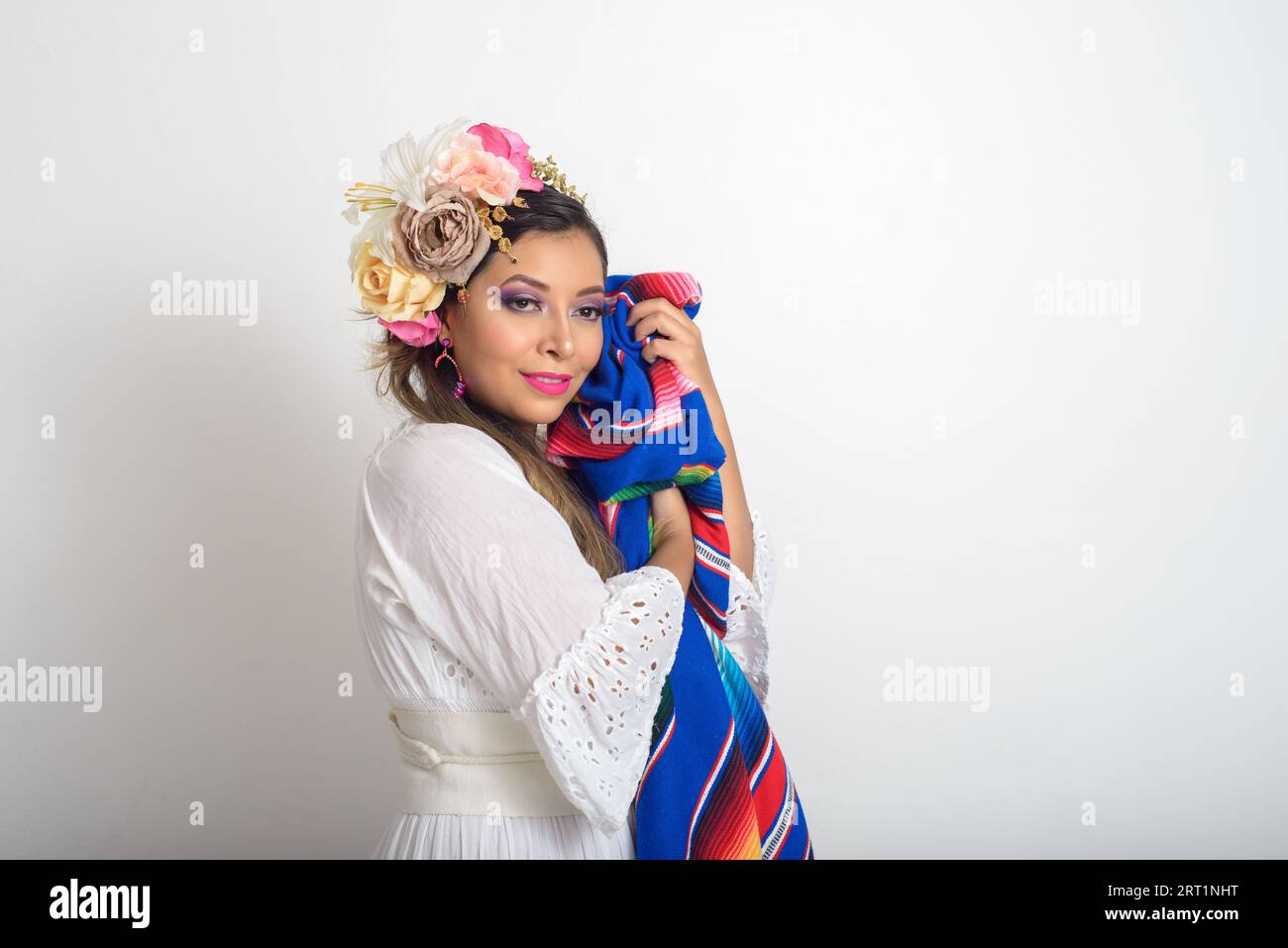 Mexican woman with flower headdress holding colorful serape. White ...