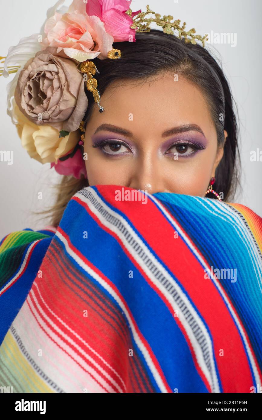 Mexican woman with flower headdress wrapped in a colorful serape. White ...