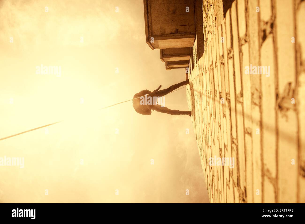 Silhouette of police officer in tactical gear descending from a height ...