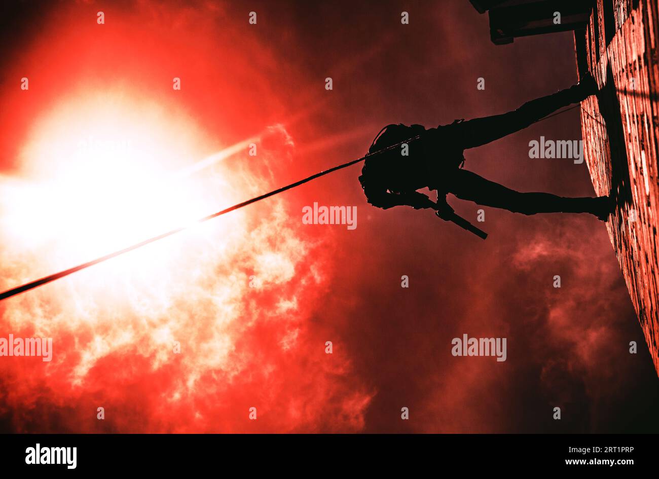 Silhouette of police officer in tactical gear descending from a height ...