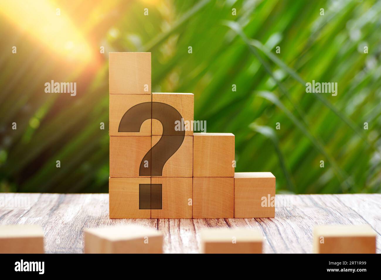 Three wooden cubes with a question mark over a beautiful bokeh nature ...