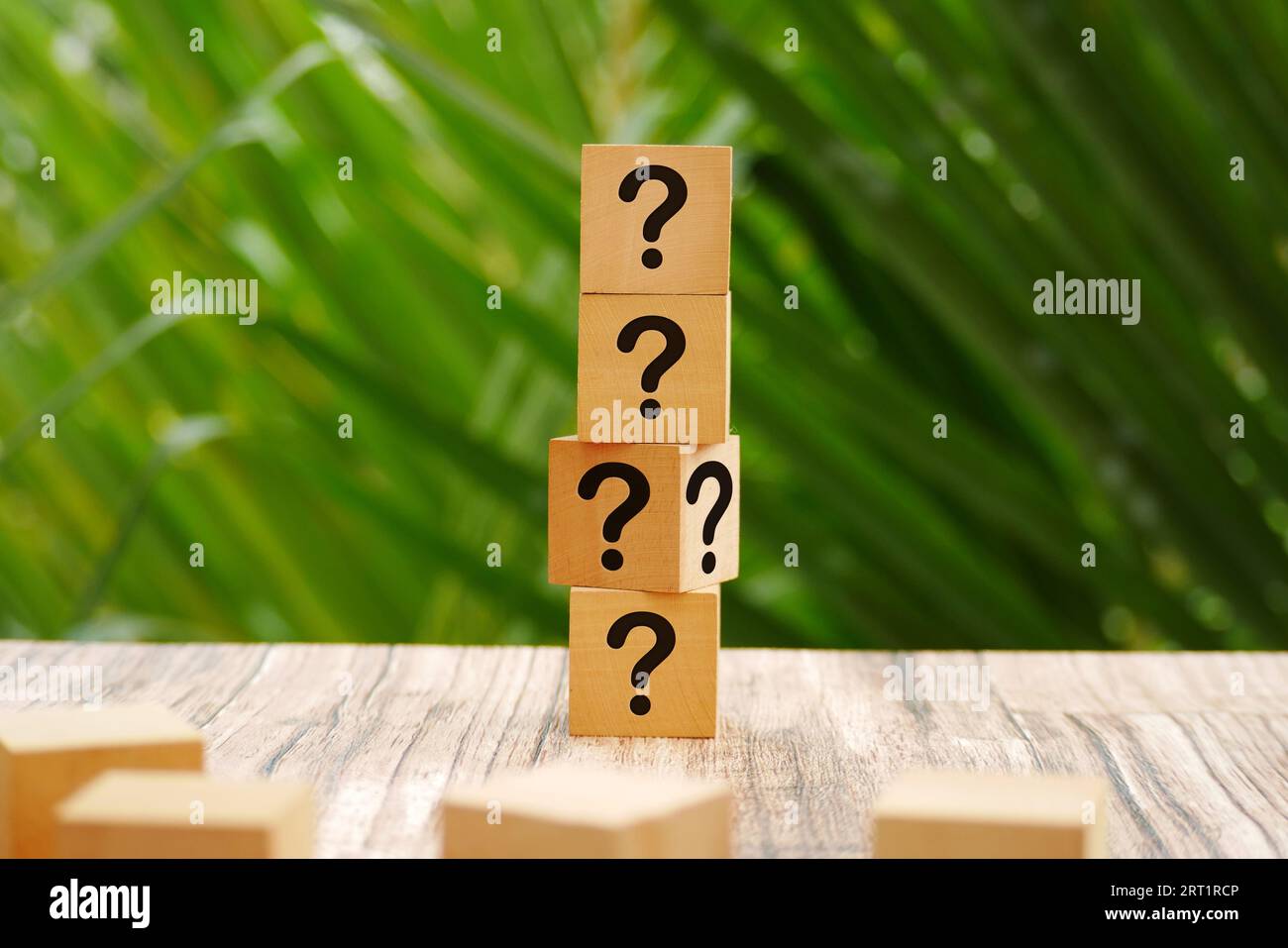 Three wooden cubes with a question mark over a beautiful bokeh nature ...