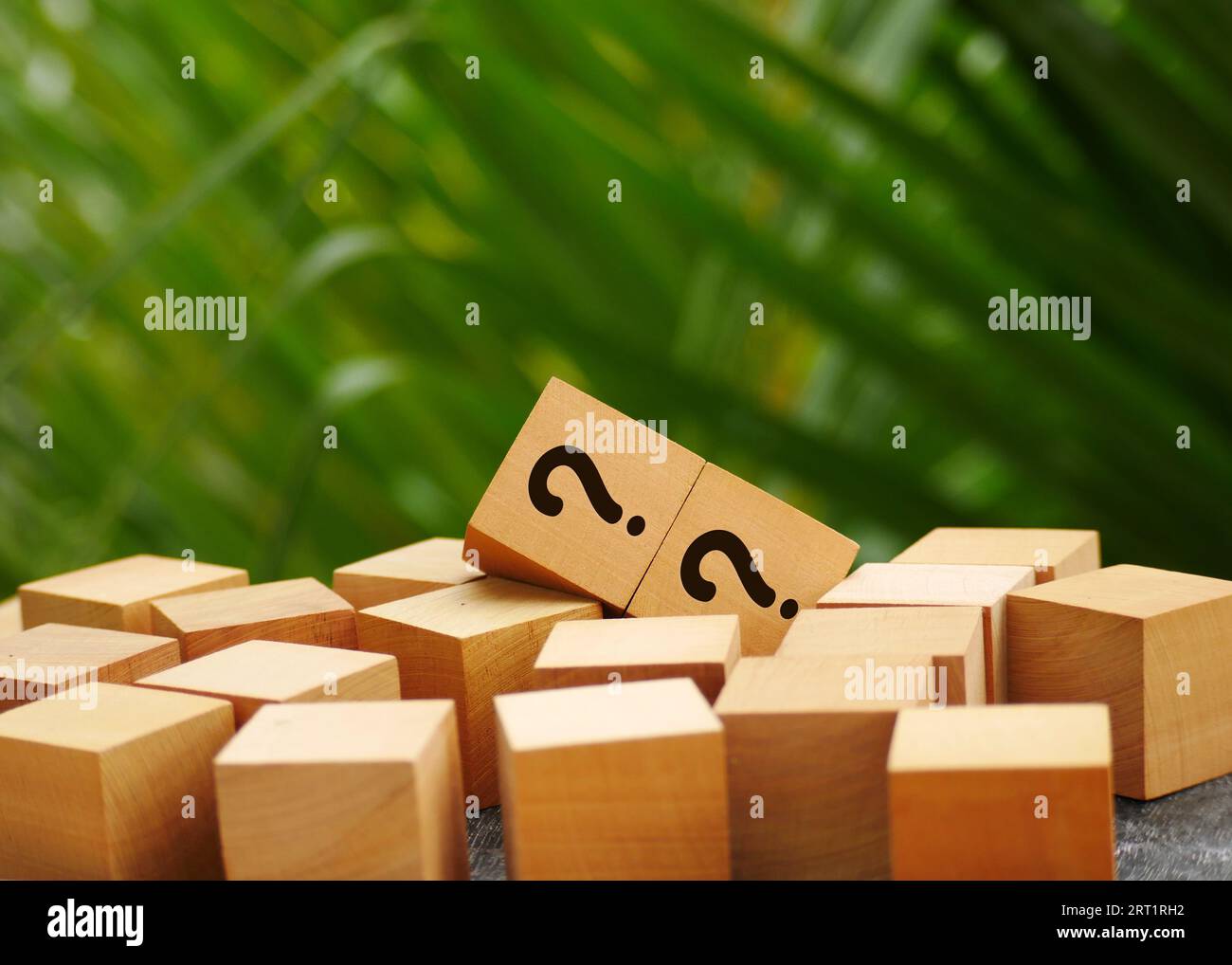 Three wooden cubes with a question mark over a beautiful bokeh nature ...