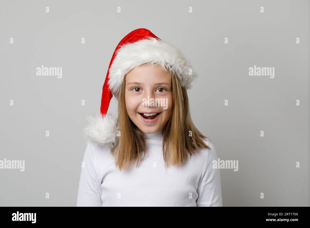 Cheerful surprised little child girl Santa having fun on white ...