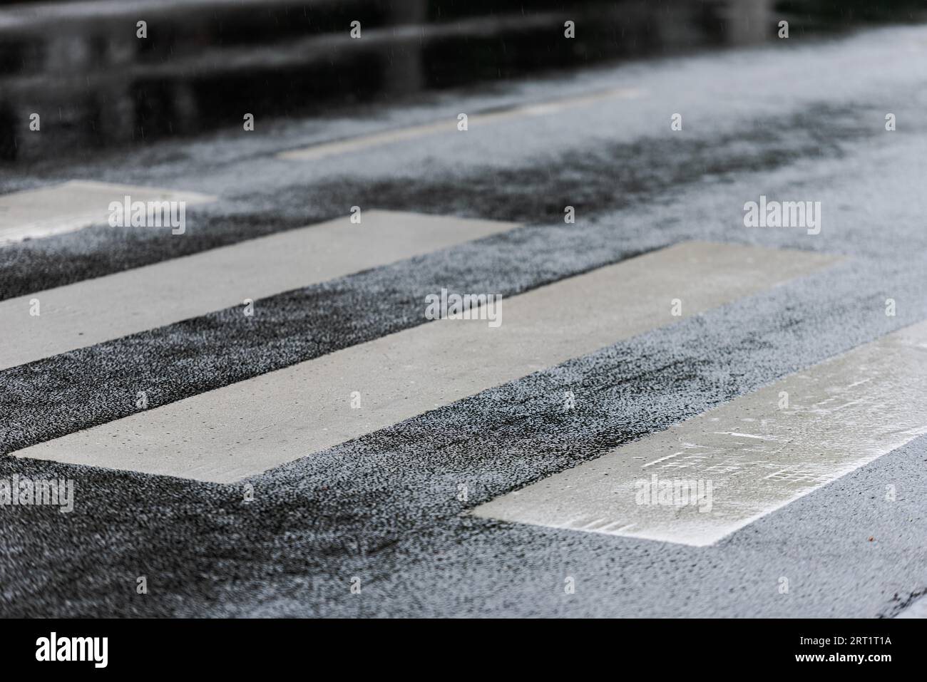 High angle detail view of pedestrian zebra crossing on wet street ...