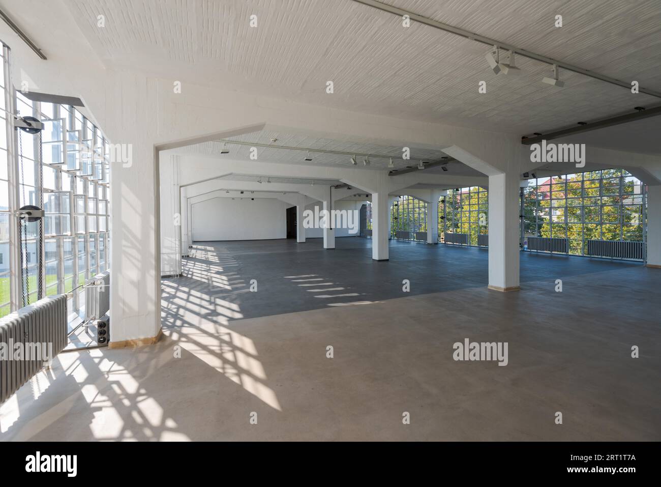 Large empty hall in the Bauhaus Dessau with big windows Stock Photo - Alamy