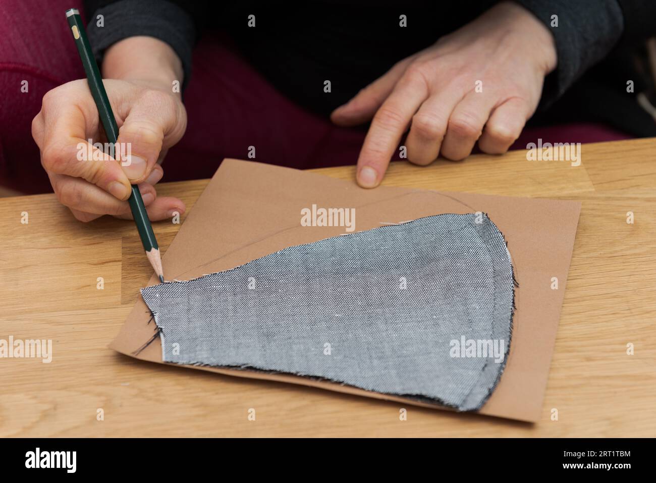 Human hands drawing a master template with lead pencil on cardboard for ...