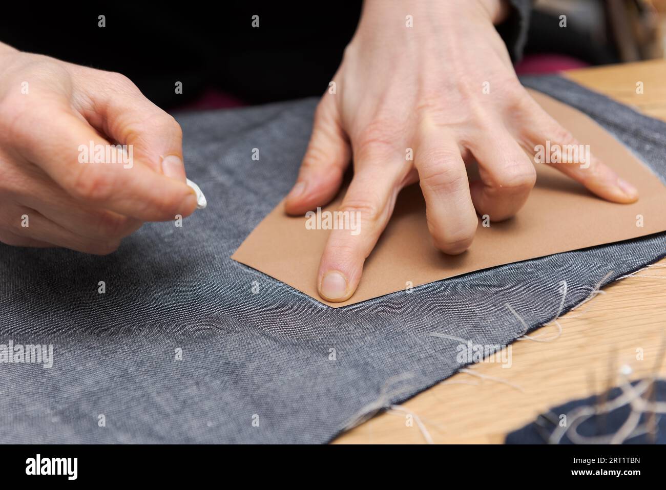 Human hands drawing a master template with tailor's chalk on fabric for ...