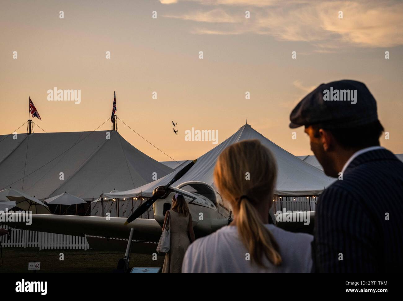 A duo of Spitfires fly as the sun sets during the Goodwood Revival at ...