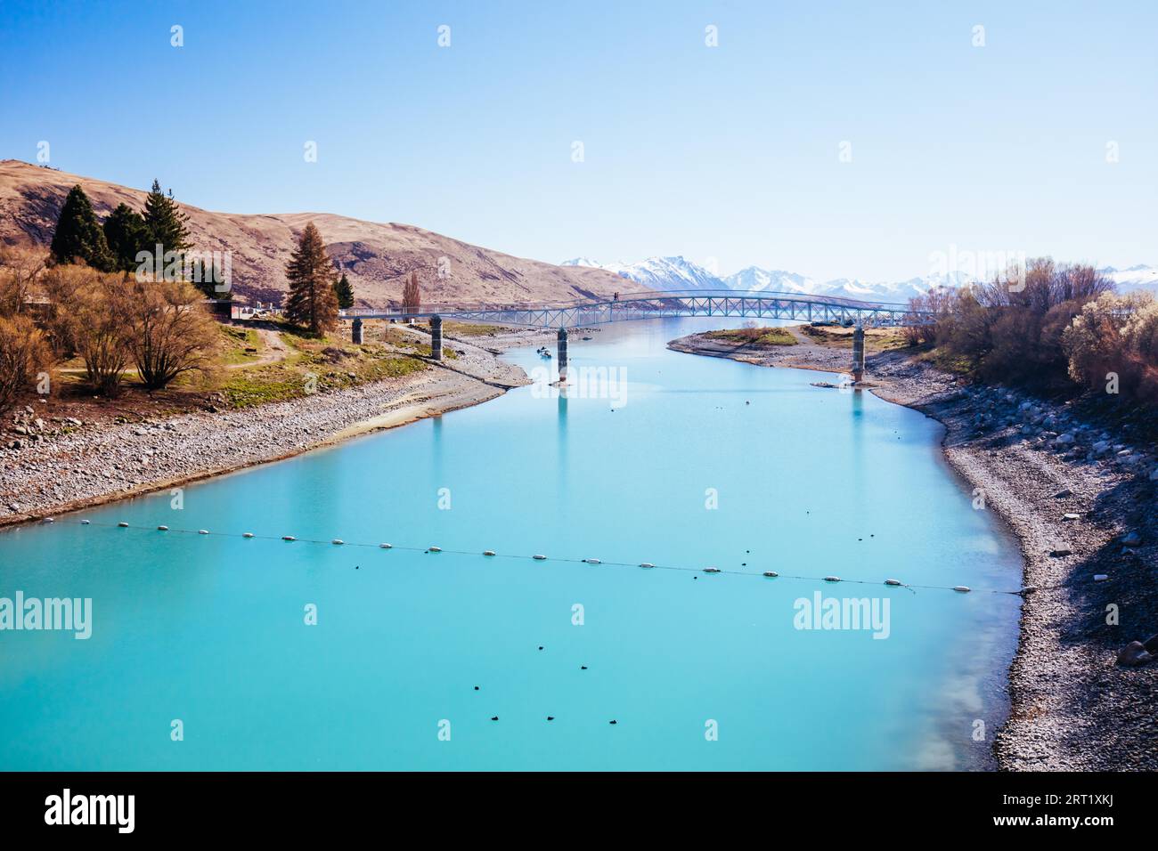 Lake Tekapo pedestrian bridge over Scott Pond on a clear spring morning ...