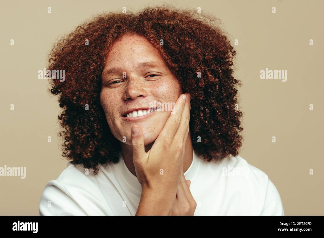 Portrait of a youthful man with ginger hair touching his beautiful ...