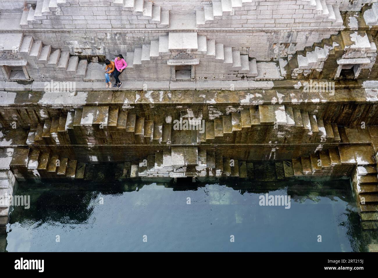 Jodhpur, India, December 8, 2019: Two girls sitting on the steps of the ...