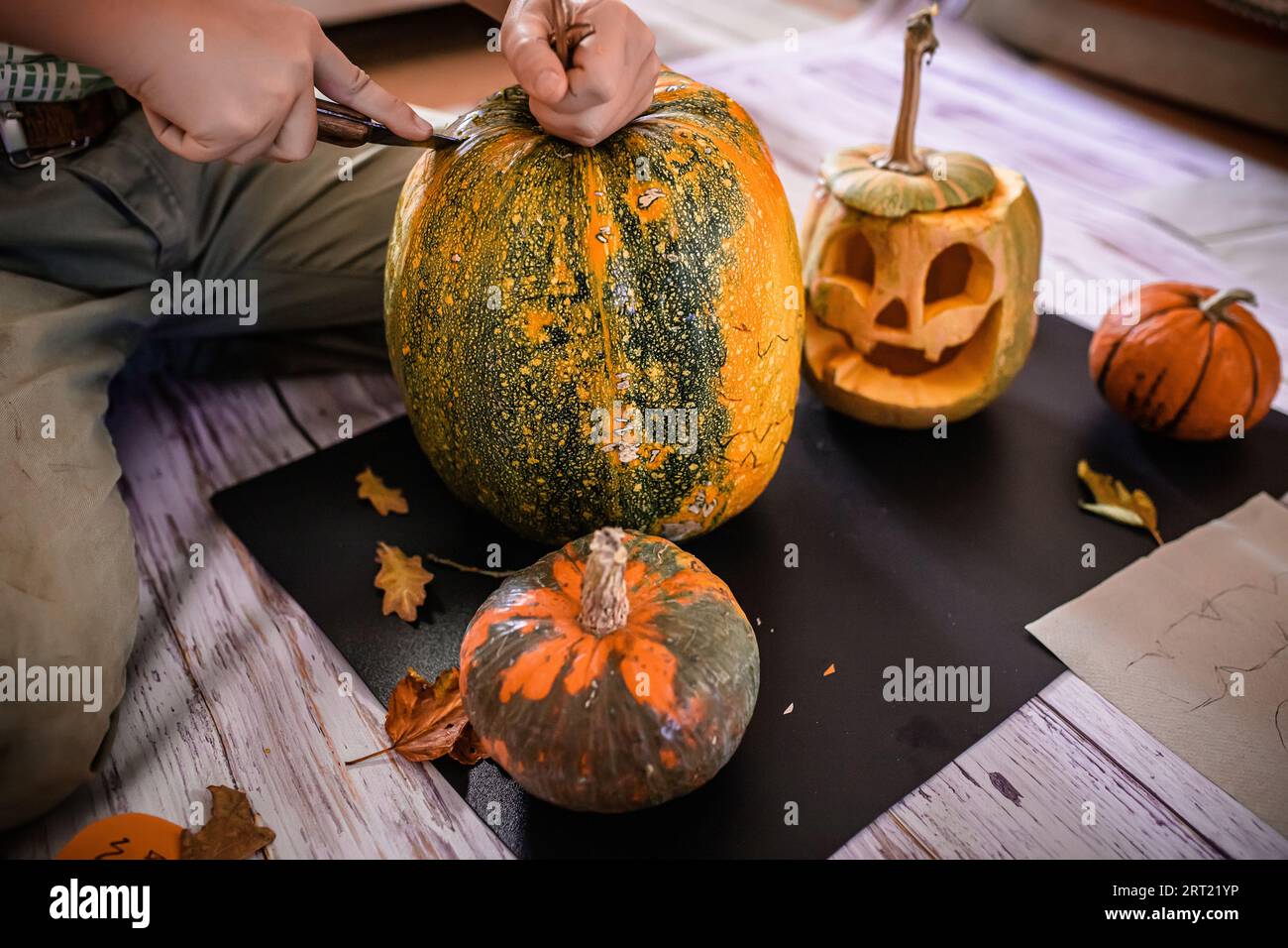 With precision, the boy's hands bring a pumpkin to life for Halloween ...