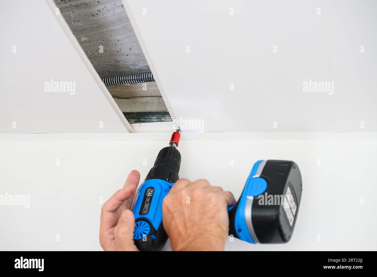 Construction worker assemble a suspended ceiling and fixing the plastic ...