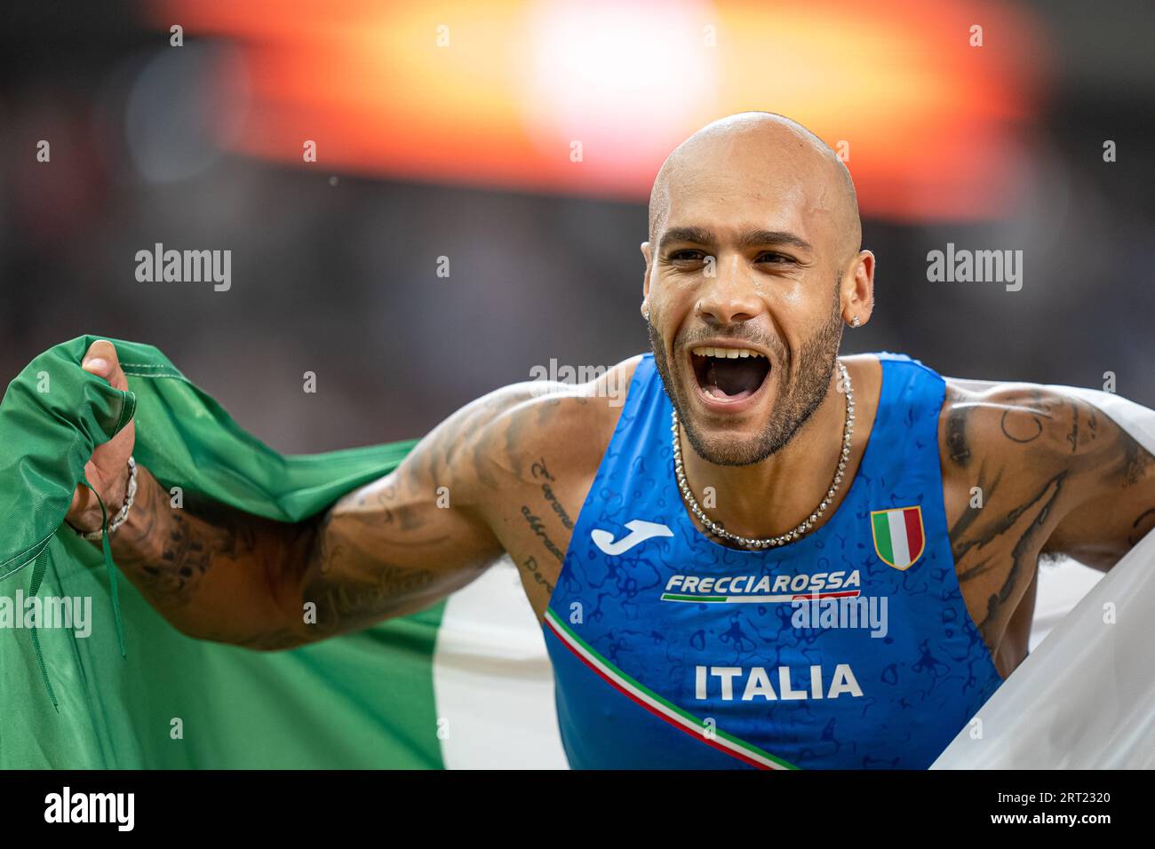 Marcell Jacobs celebrating her medal with her country's flag in the ...