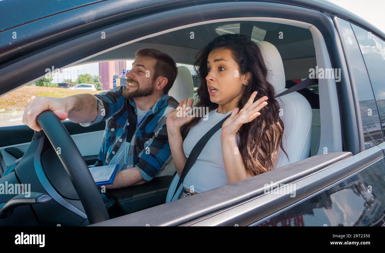 Worried male instructor sitting aside the woman and looking nervous at ...