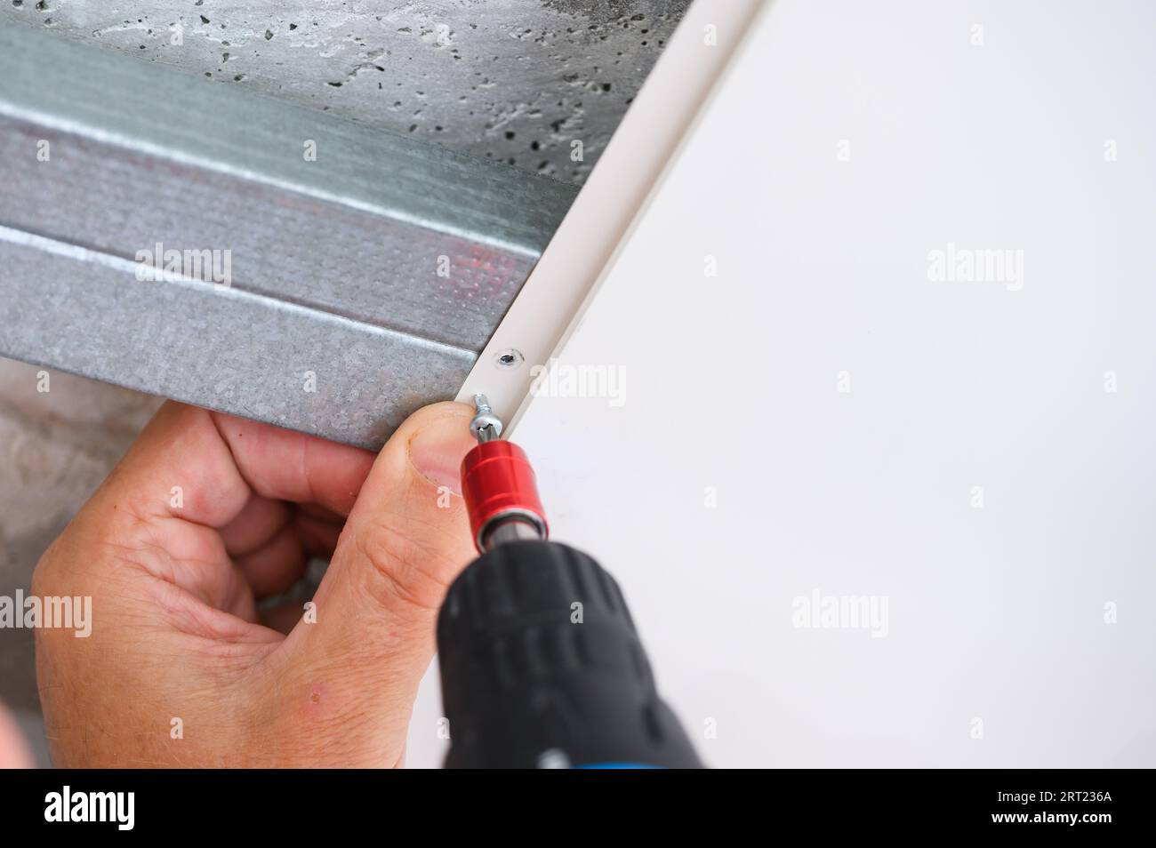 Construction worker assemble a suspended ceiling and fixing the plastic ...