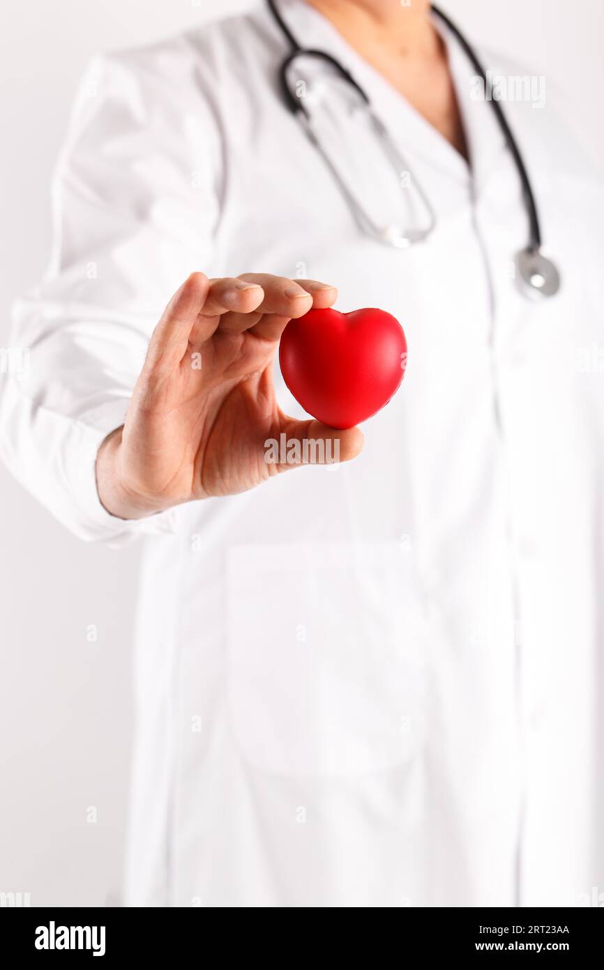 Male doctor holding heart in hands symbol of health Stock Photo - Alamy