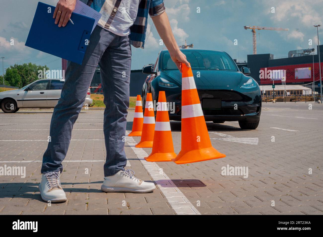 Instructor near car with his female student during exam at driving ...