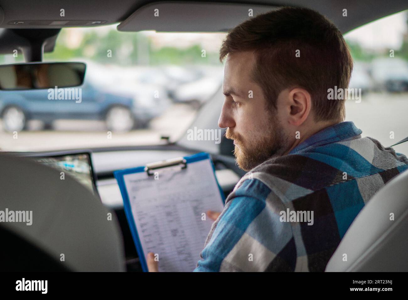 Instructor holding drive test report while sitting on the passenger ...