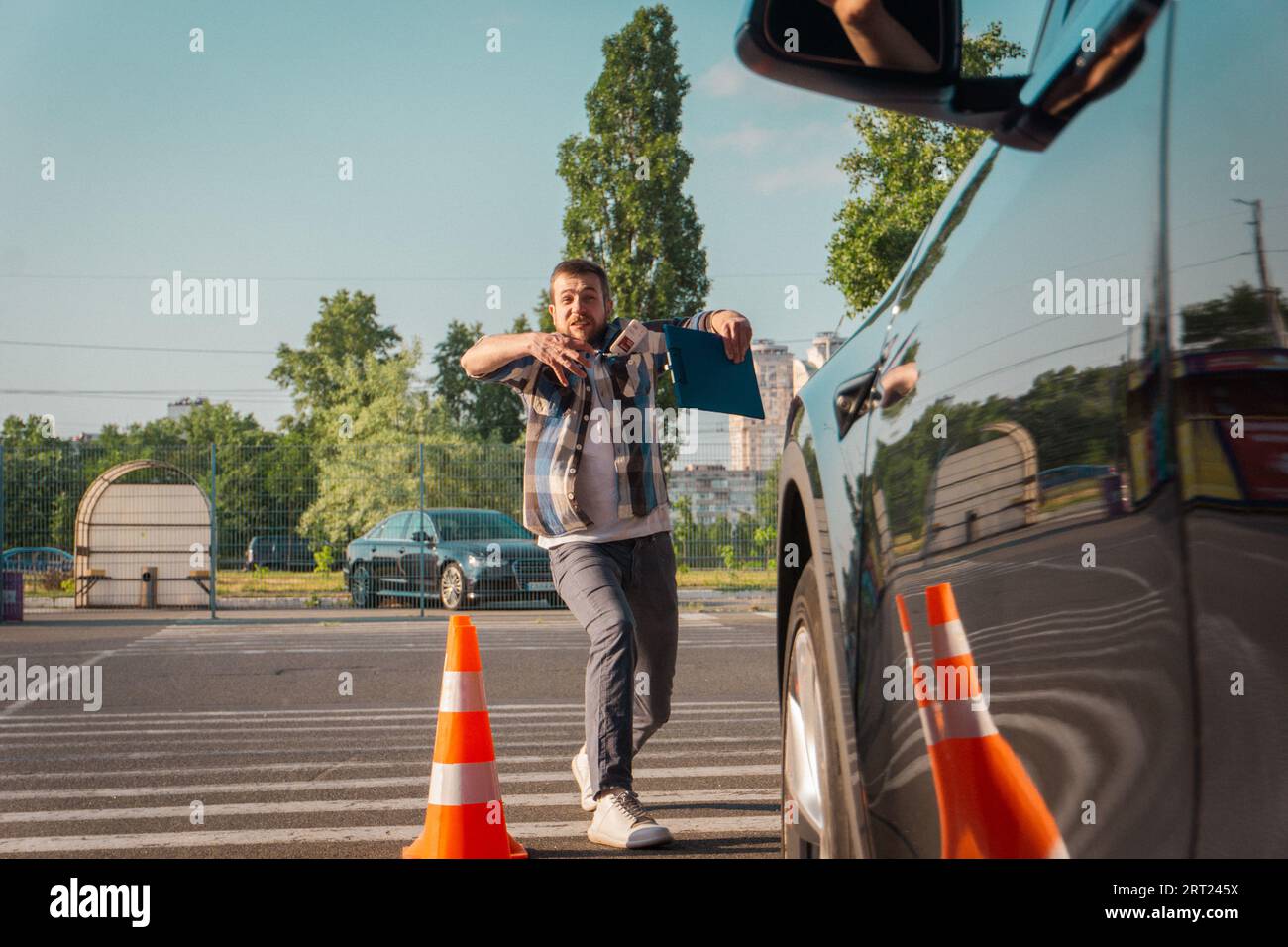 Driving instructor gesturing with his hands during training how to park ...