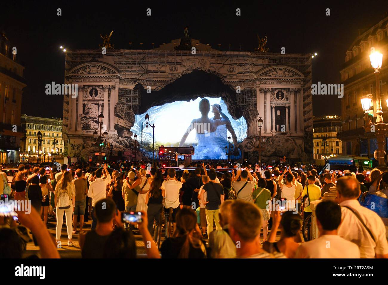 People in front of an installation by French artist JR, depicting the ...