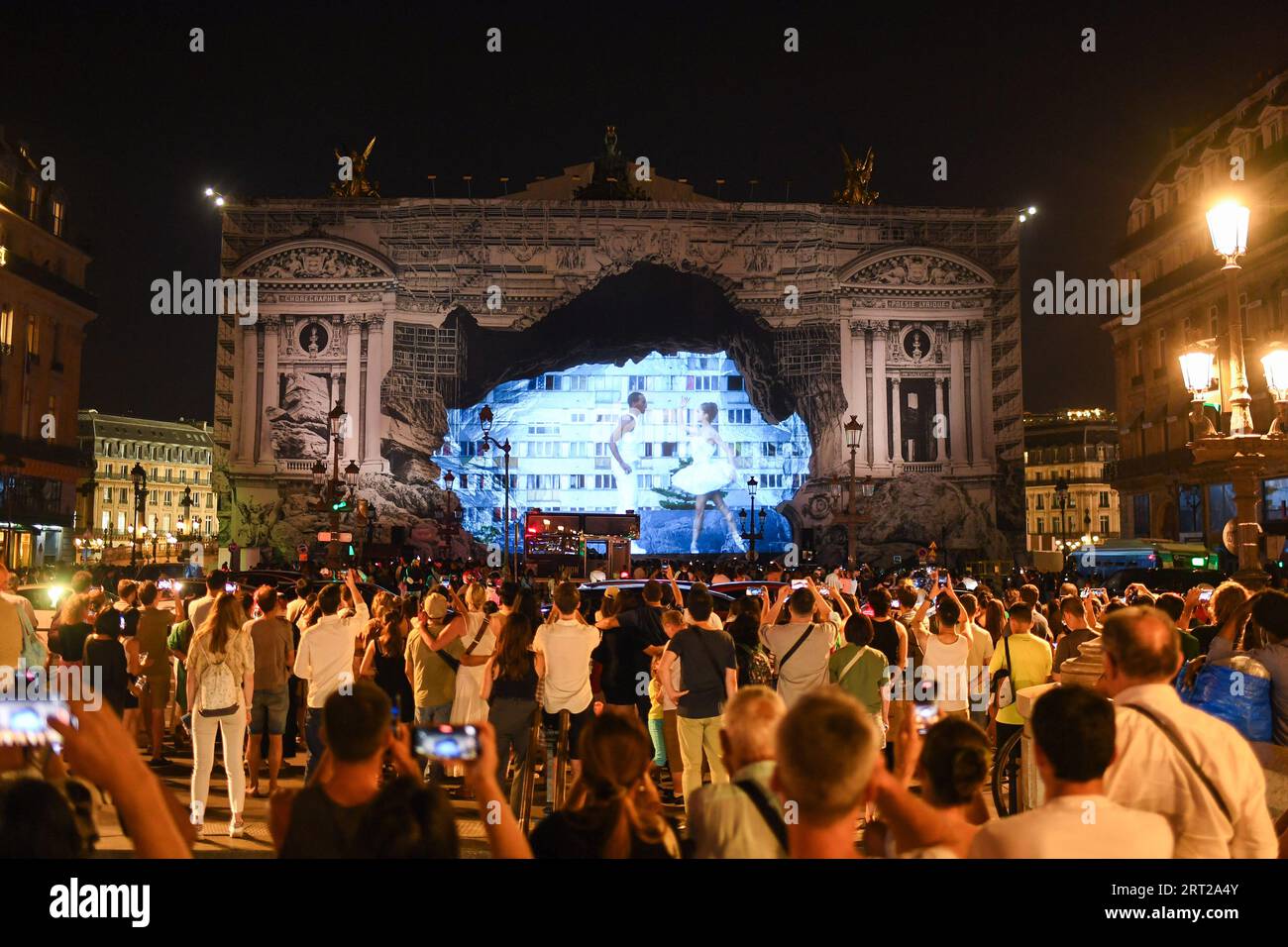 People in front of an installation by French artist JR, depicting the ...