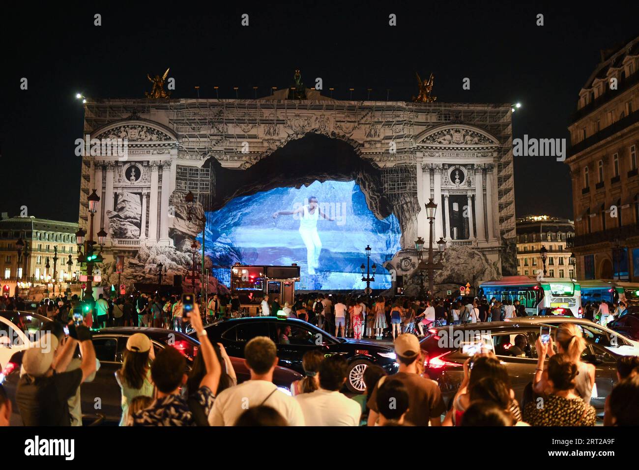 People in front of an installation by French artist JR, depicting the ...