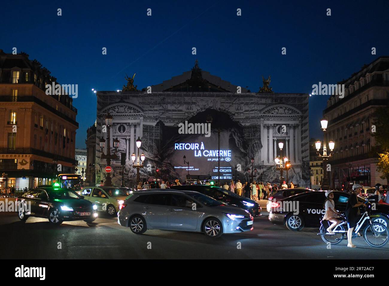 People in front of an installation by French artist JR, depicting the ...