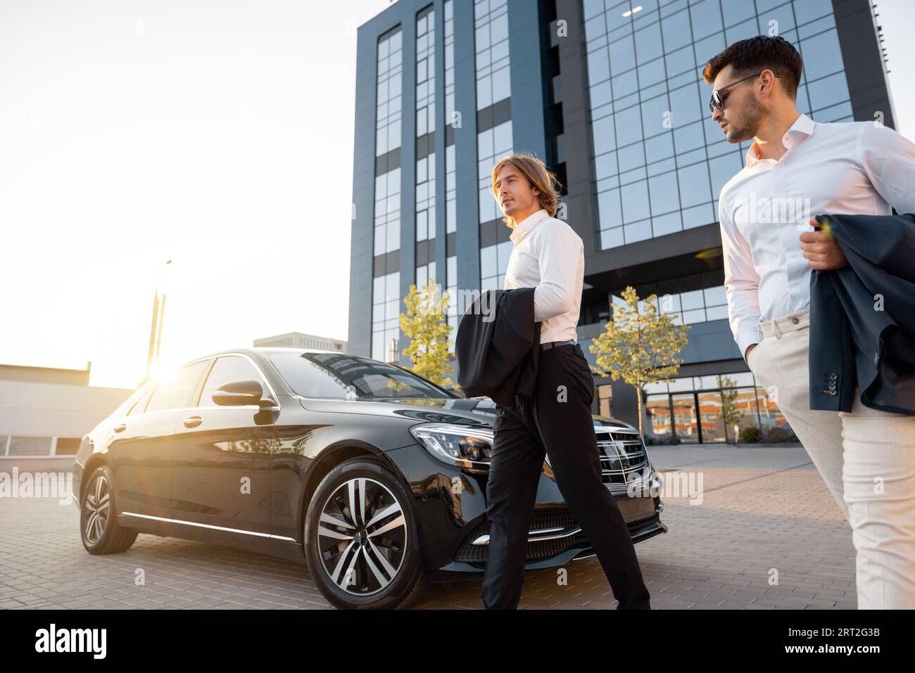 Two businessmen going to go by car after work Stock Photo - Alamy