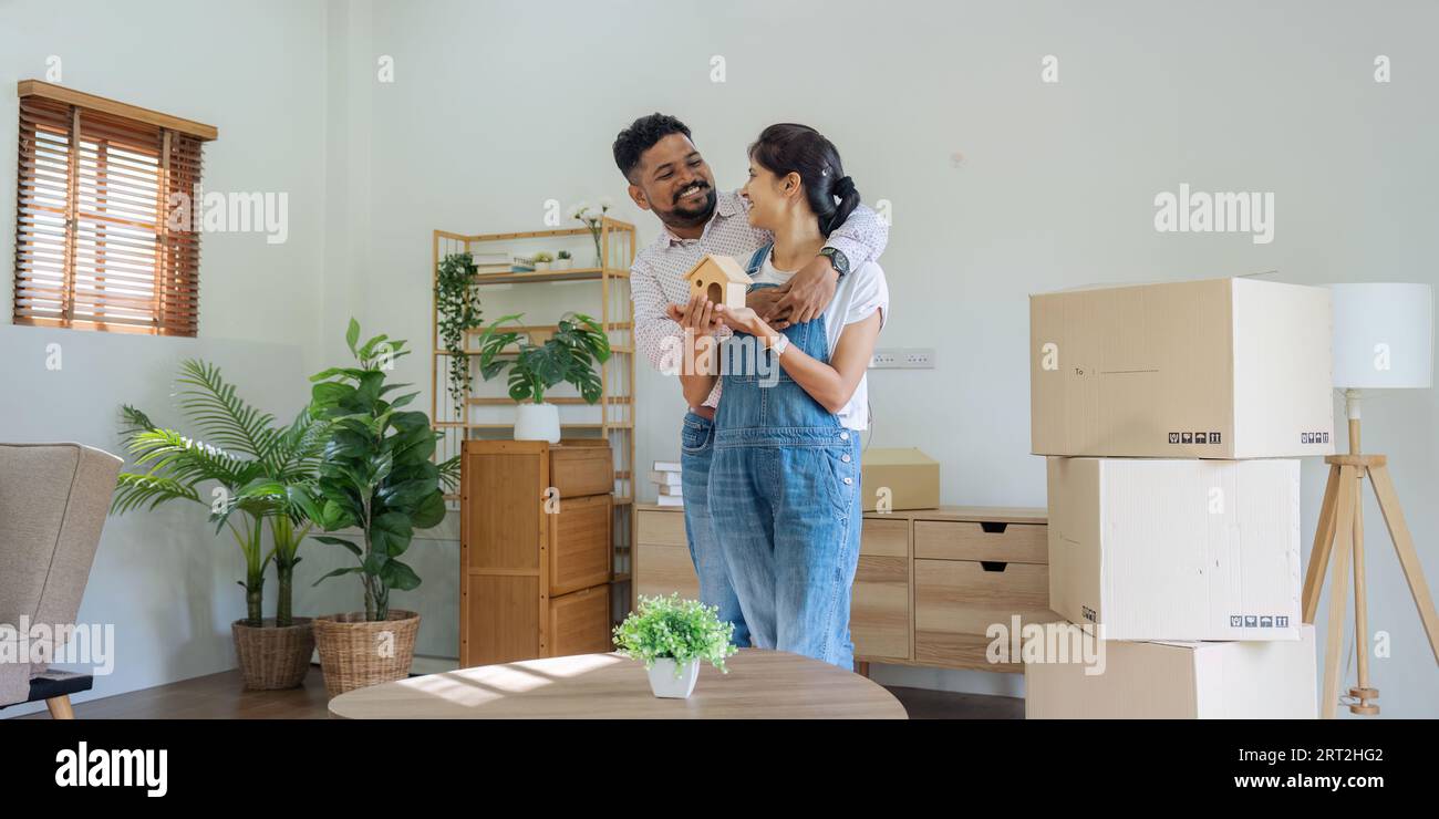 Married Indian Couple Owners Holding House Model Moving In New Home