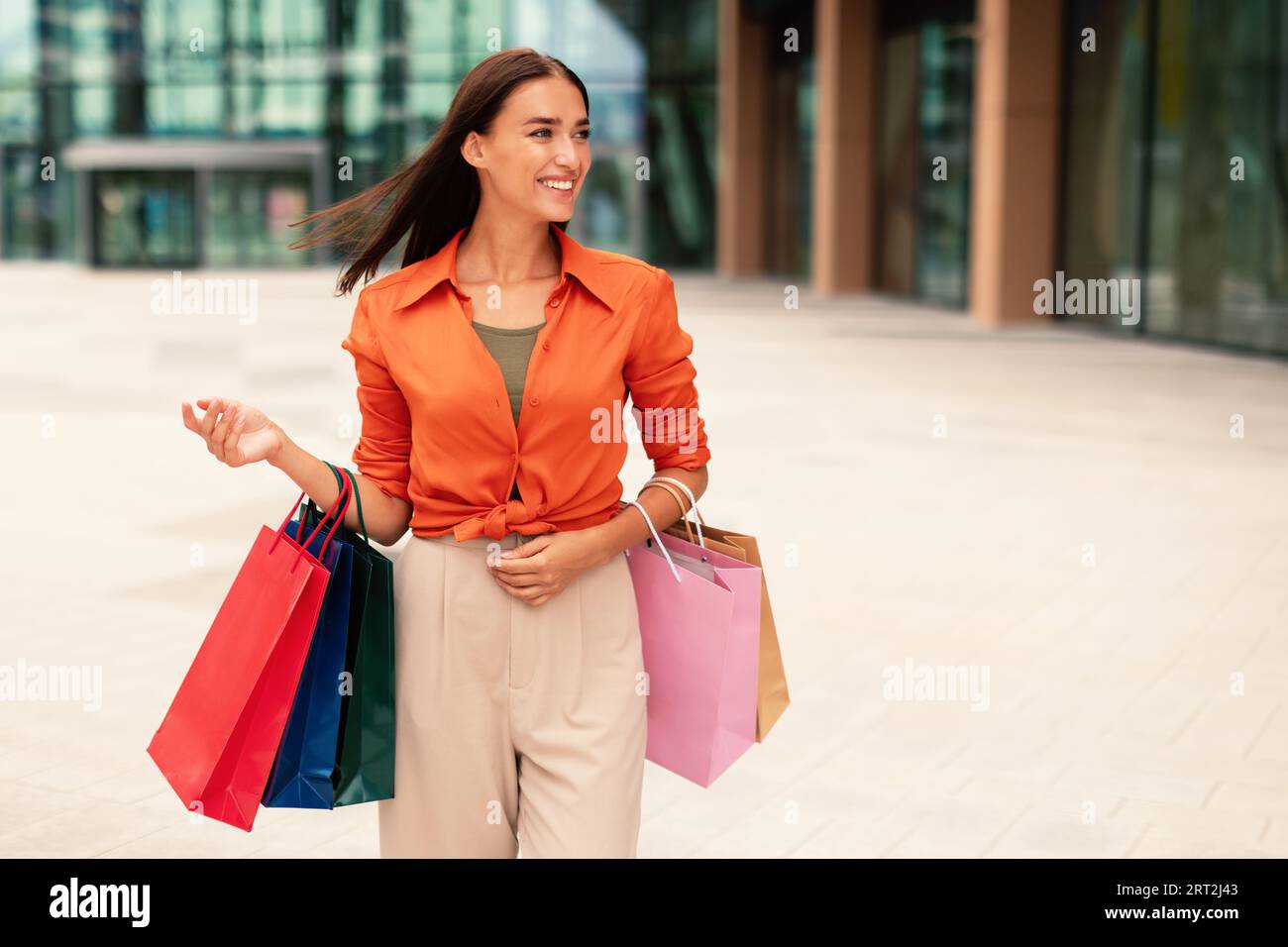 Happy lady posing with many shopper bags shopping in city Stock Photo ...