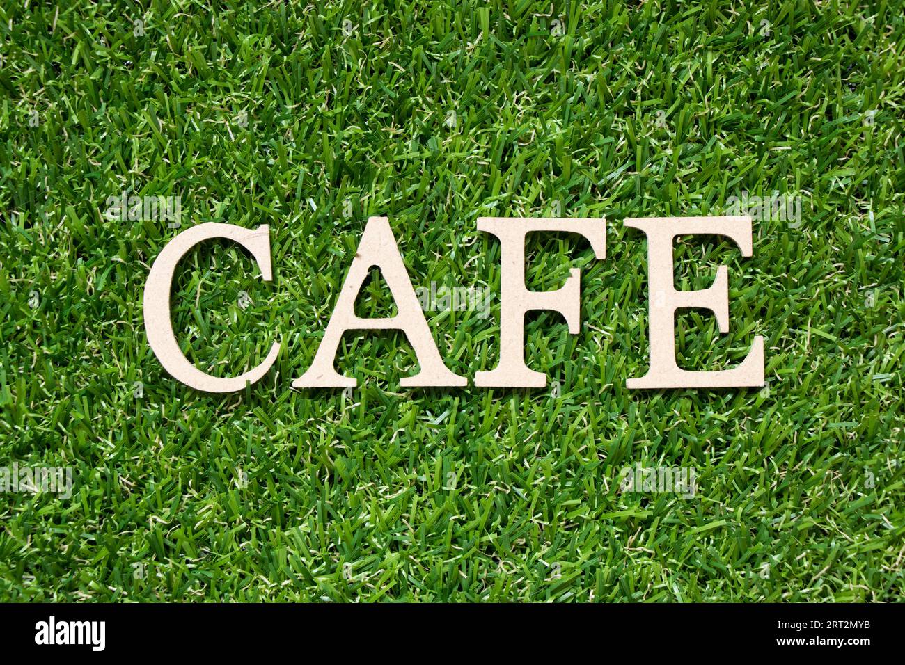 Wood alphabet letter in word cafe on artificial green grass background ...