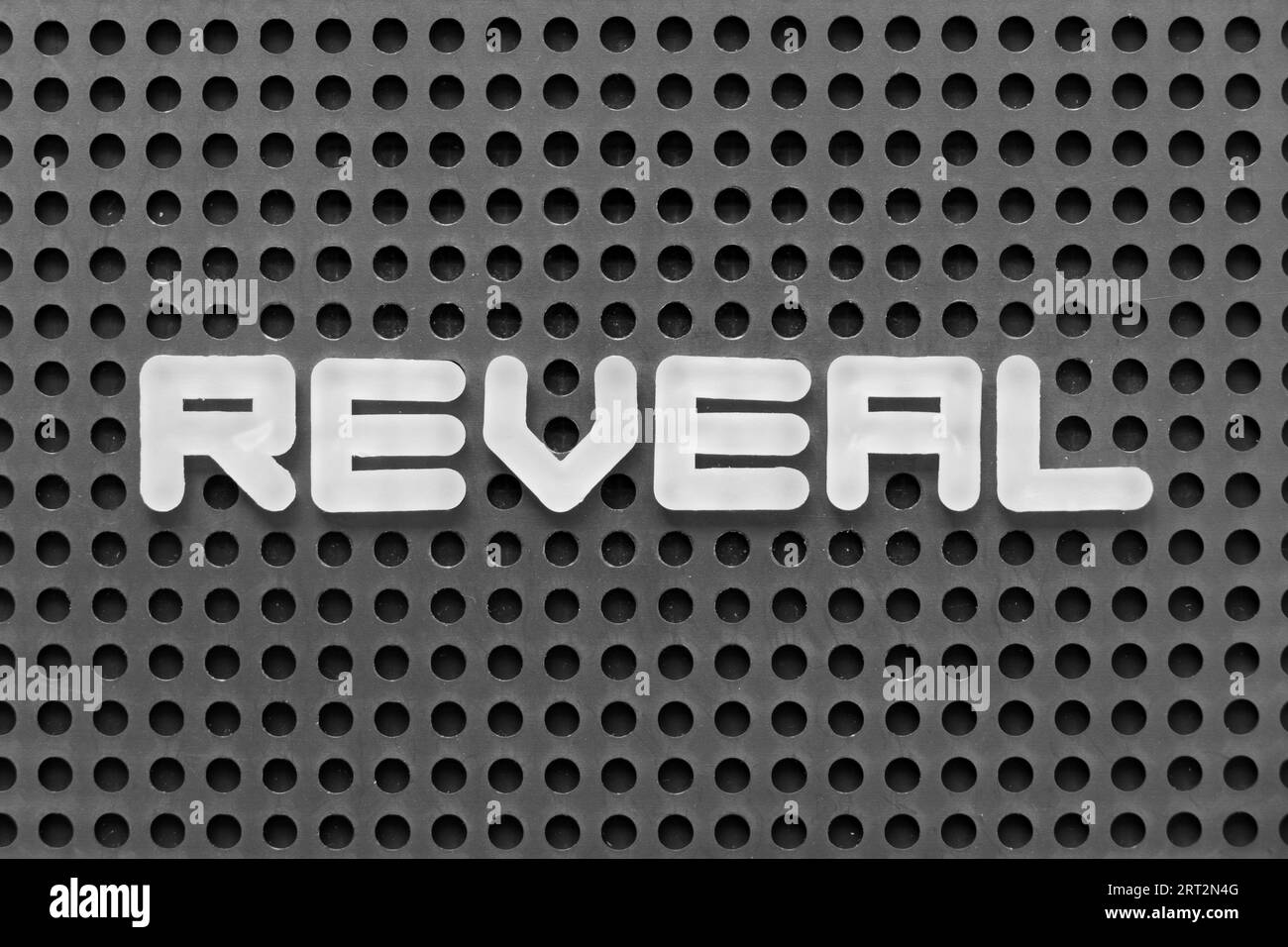 White alphabet letter in word reveal on black pegboard background Stock ...