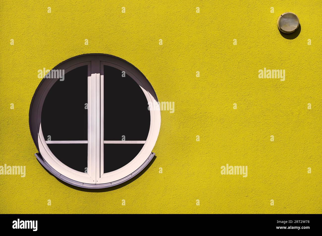 Yellow house wall with round window Stock Photo - Alamy