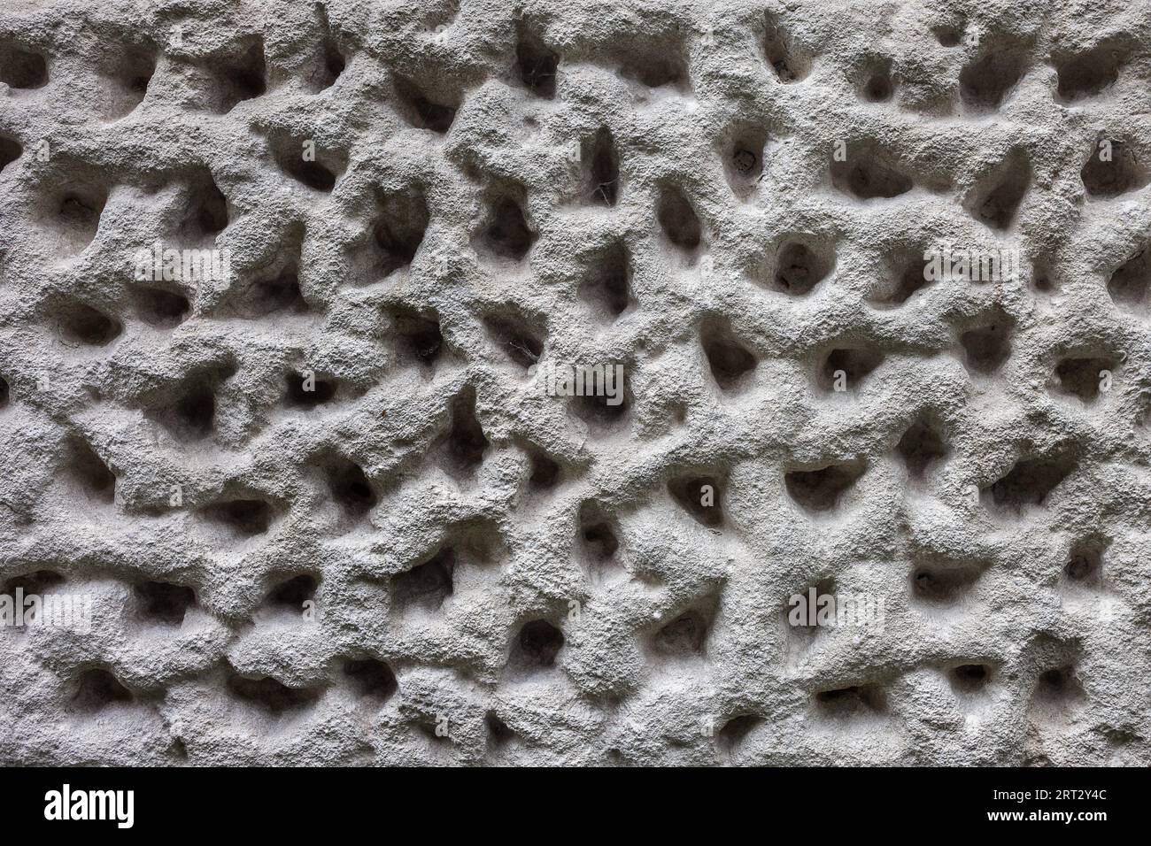 Porous stone wall with holes background texture Stock Photo - Alamy