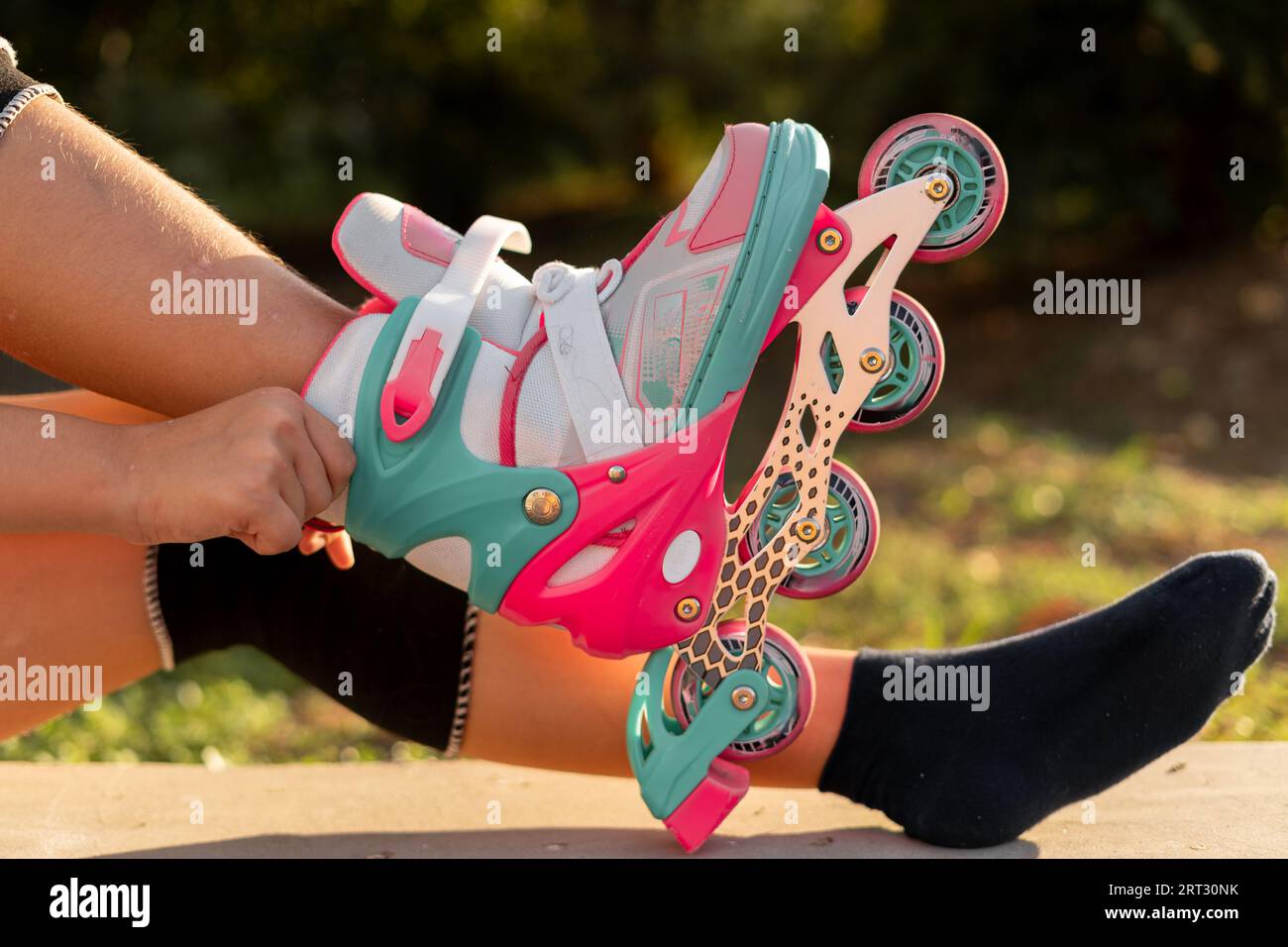 Girl putting up roller skate shoes on legs, fun summer fitness activity ...
