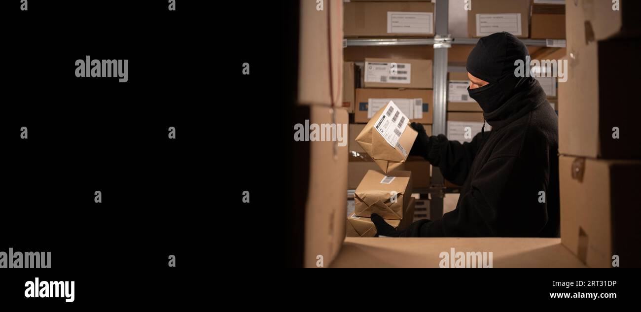 A thief stealing boxes in a warehouse at night in the dark. Warehouse ...