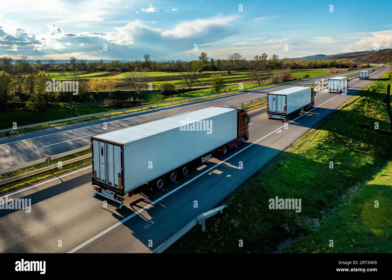 Large Transportation Trucks departing on a highway road through the ...