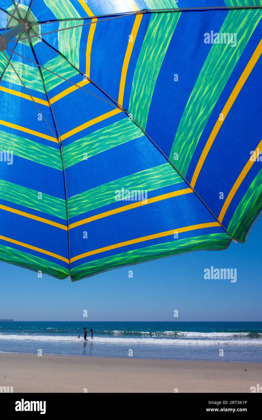 Getting shade under an brightly colored umbrella on Dockweiler State ...