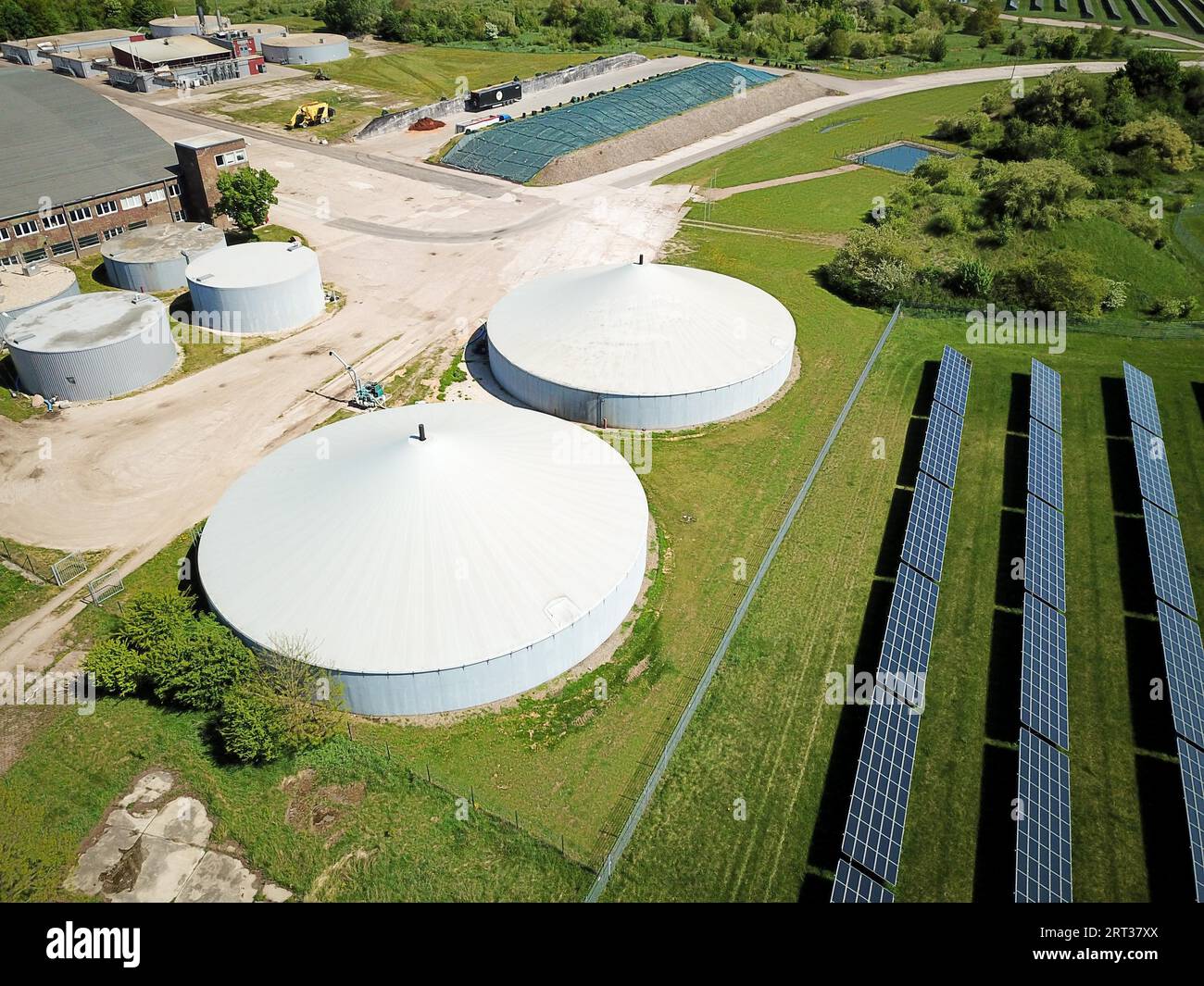 Solar panels in the sun and a biogas plant Stock Photo - Alamy