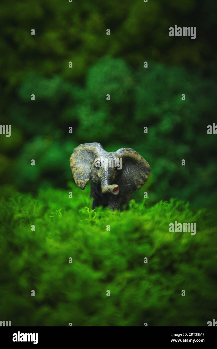 Miniature figurine of an elephant on a natural background. World animal ...