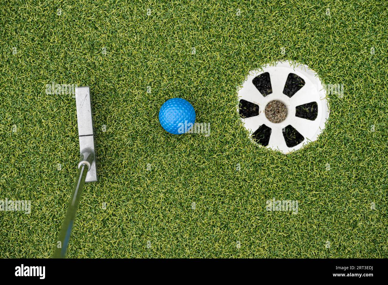 Miniature golf putter by blue ball and hole Stock Photo - Alamy