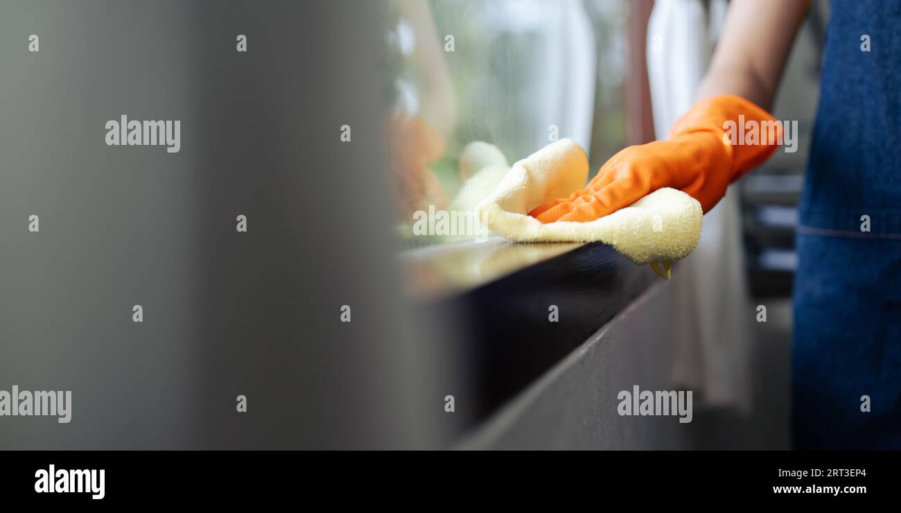 Woman wiping the edge window with microfiber cloth. Close-up detail ...