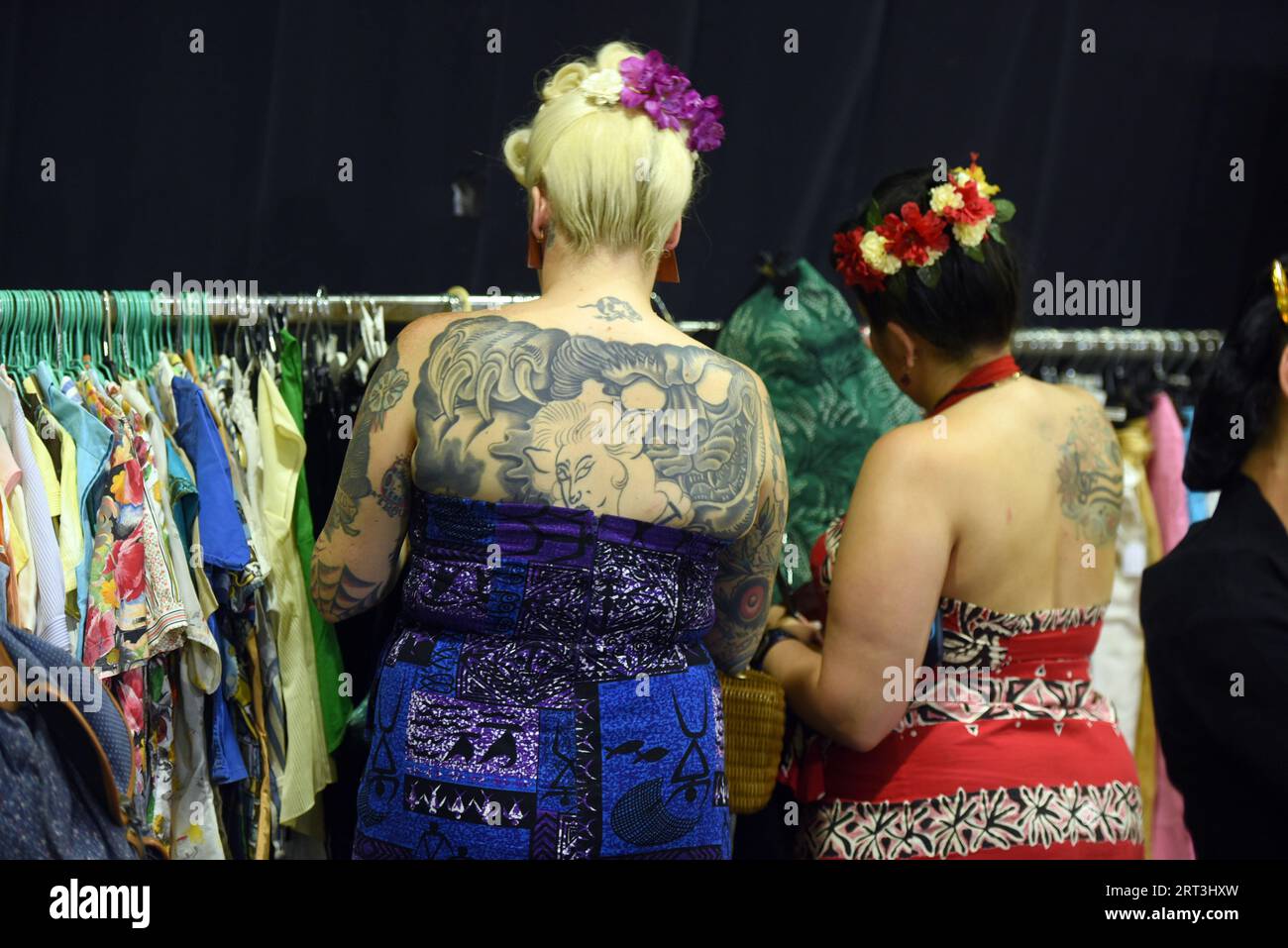 Two women dressed in Pin-Up aesthetic look at clothes in a store during ...