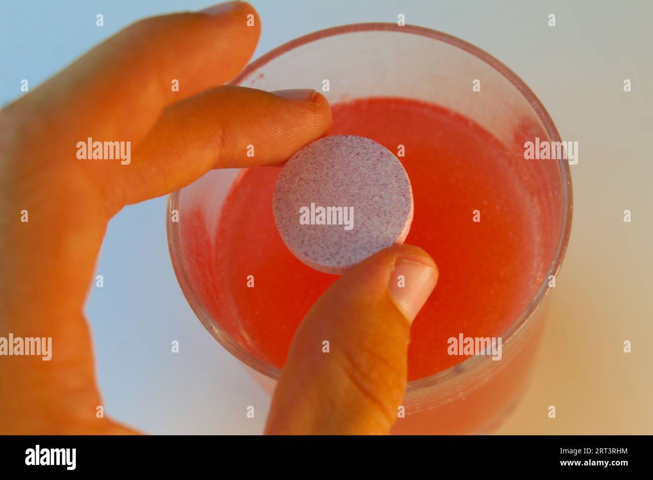A photo of someone dropping an electrolyte tablet into a glass of water ...